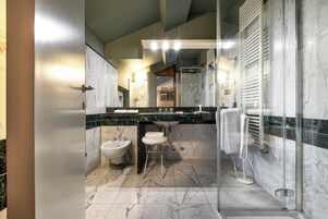 Uma casa de banho moderna com bidé, lavatório e cabine de duche em vidro.