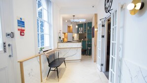 Cozinha moderna com bancada de mármore, uma cadeira de madeira e vista para a área de estar.