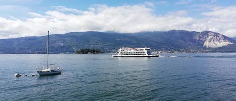 Um lago com um veleiro e um ferry.