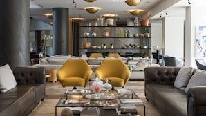 Uma sala de estar moderna com dois sofás, uma mesa de centro e uma estante cheia de objetos decorativos.