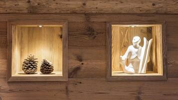 Duas vitrines de madeira com pinhas e uma escultura em cerâmica.