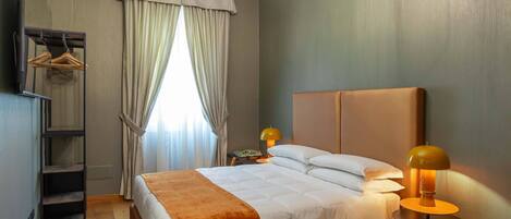 Quarto de hotel bem arrumado com uma cama, abajures, guarda-roupa e uma janela com cortinas.
