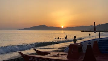 Cena de praia com um barco chamado 'Marco Beach' e outro barco com a inscrição 'SALVATAGGIO'.