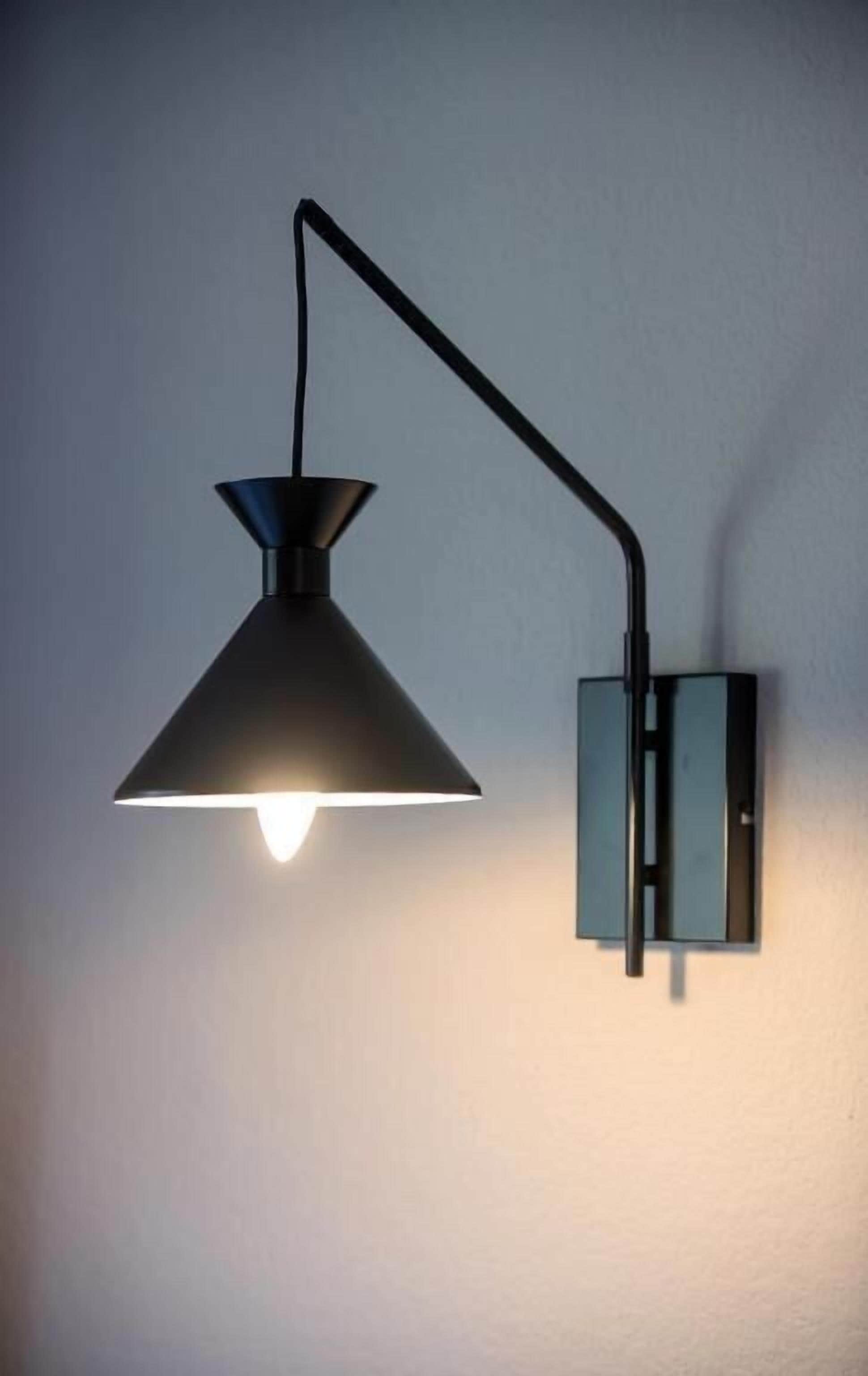 Uma luminária de mesa fixada na parede, com cúpula cônica e interruptor também na parede.
