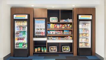 Uma área de distribuição automática com várias máquinas de bebidas e snacks.