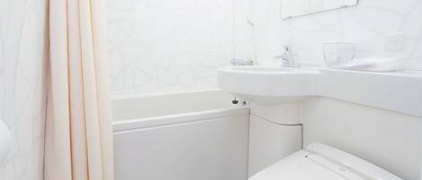 Um banheiro moderno com banheira, pia e vaso sanitário.