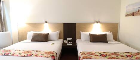 Quarto de hotel com duas camas, cada uma com cabeceira, mesas de cabeceira e abajures.