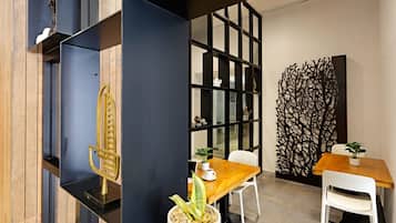 Uma sala de jantar moderna com mesa de madeira, cadeiras brancas e plantas em vasos.