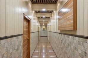 Um corredor com azulejos estampados, lambris de madeira e chão de azulejos.