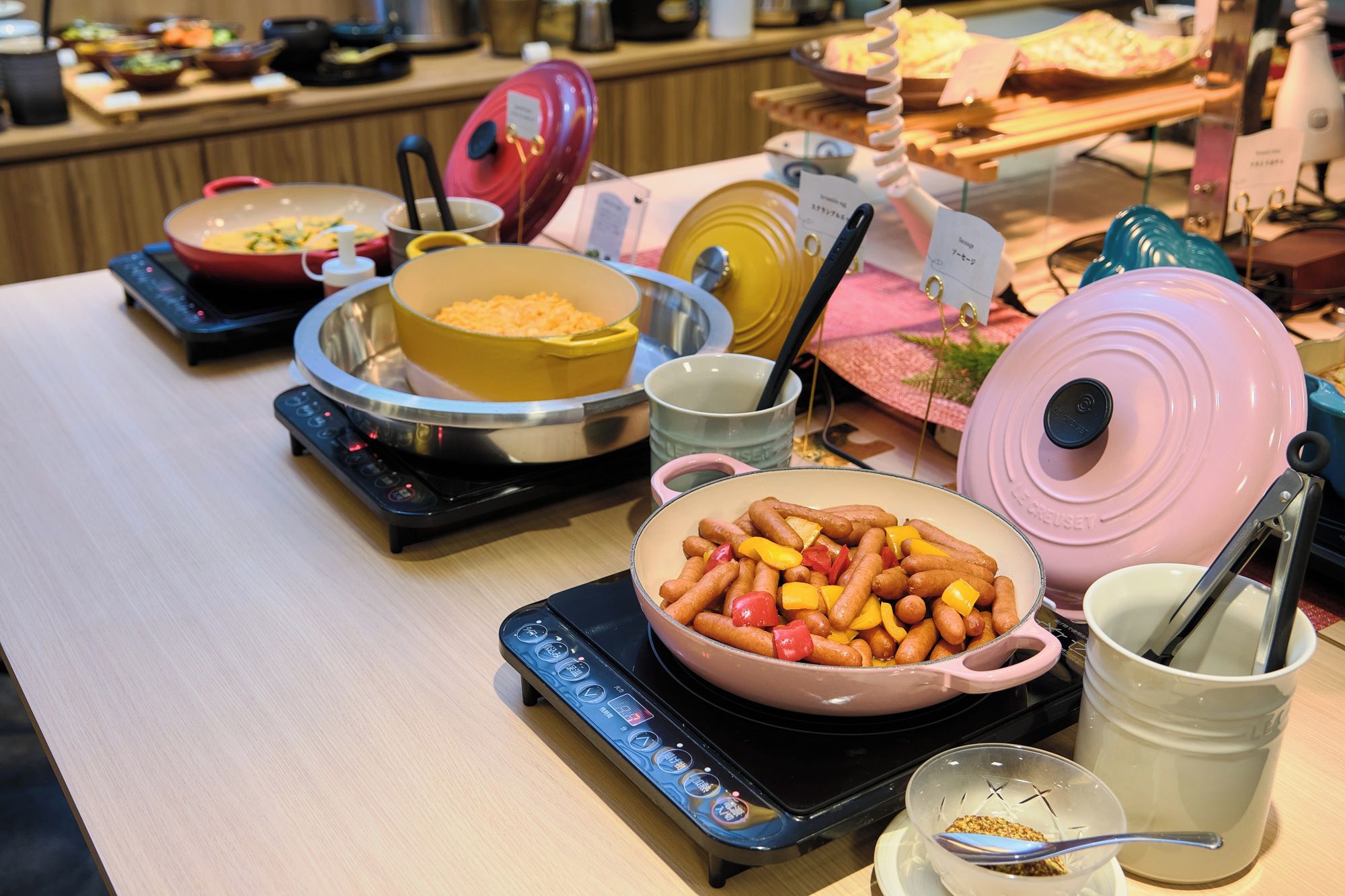 Uma mesa de buffet com diversos pratos e utensílios de cozinha.