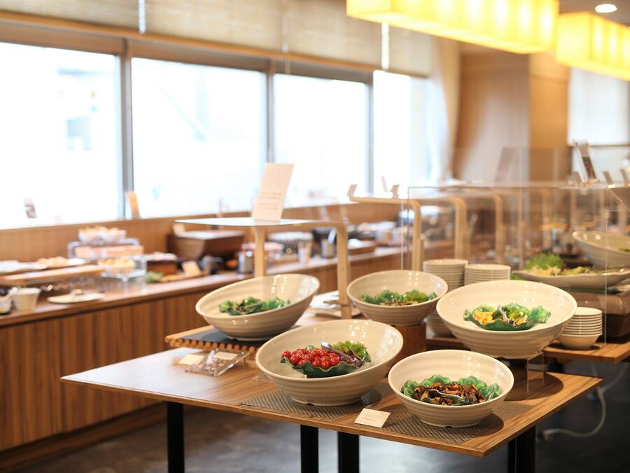 Uma mesa de buffet com diversos pratos e recipientes.