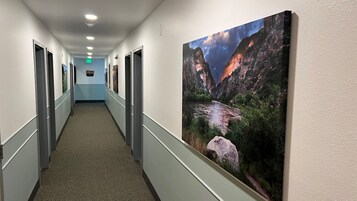 Um corredor com uma pintura grande de um cânion e um rio na parede da direita.