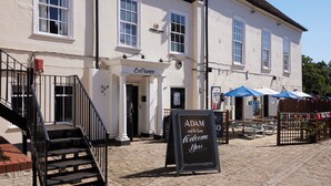 A building with a sign reading "Entrance" and a signboard that says "ADAM and the team Welcome You."