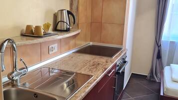Uma cozinha compacta com uma pia dupla, eletrodomésticos de aço inoxidável e um pequeno balcão.