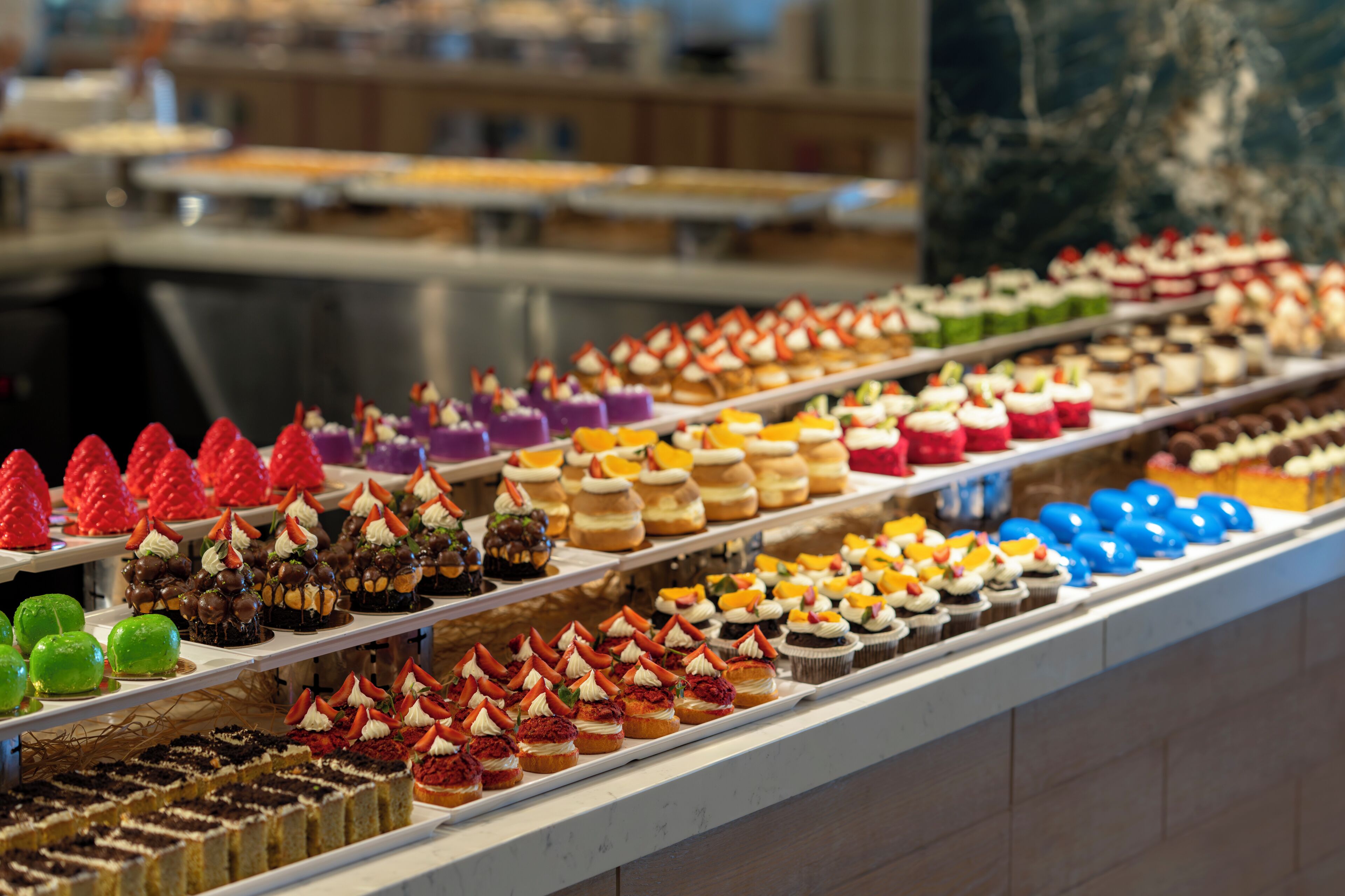 Diversas sobremesas expostas em um buffet.