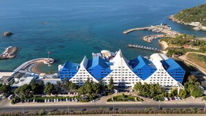 Hotel costeiro com design moderno, com um porto de iates e vista para o mar.
