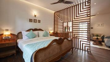 Quarto com cama de madeira, luminárias de cabeceira, ventilador de teto e divisória decorativa.