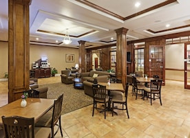Um hall de hotel espaçoso com área de estar, estação de café e televisão.