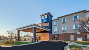 Um Best Western Inn & Suites com entrada coberta, fachada de tijolos e várias janelas.