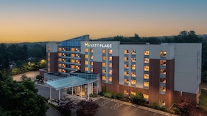 Um hotel de vários andares com entrada de vidro e uma placa indicando "HYATT PLACE".