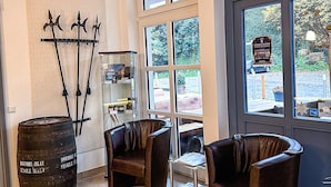 Um interior acolhedor com poltronas de couro, área de bar e grandes janelas com vista para o exterior.