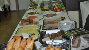 Uma mesa de buffet com diversos alimentos e um castiçal.