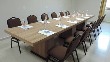 Uma sala de conferência com uma mesa comprida, cadeiras, garrafas de água e cartões de identificação.
