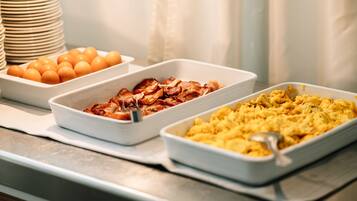 Um buffet de café da manhã com ovos, bacon e ovos mexidos.