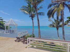 Na praia, espreguiçadeiras, guarda-sóis, toalhas de praia 