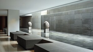 Um lobby moderno com piso refletivo, assentos geométricos e parede texturizada.