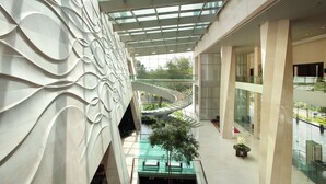 Um interior moderno com design de parede curva, um elemento central de água e teto de vidro.
