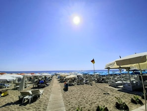 Praia particular, espreguiçadeiras, guarda-sóis, toalhas de praia 