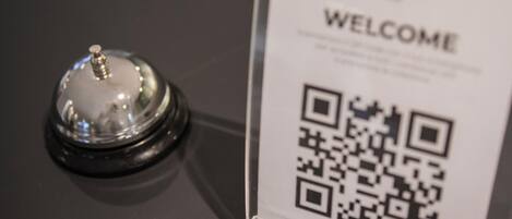 Uma vitrine de vidro transparente com um código QR e um letreiro de boas-vindas, provavelmente para um hotel ou estabelecimento similar.