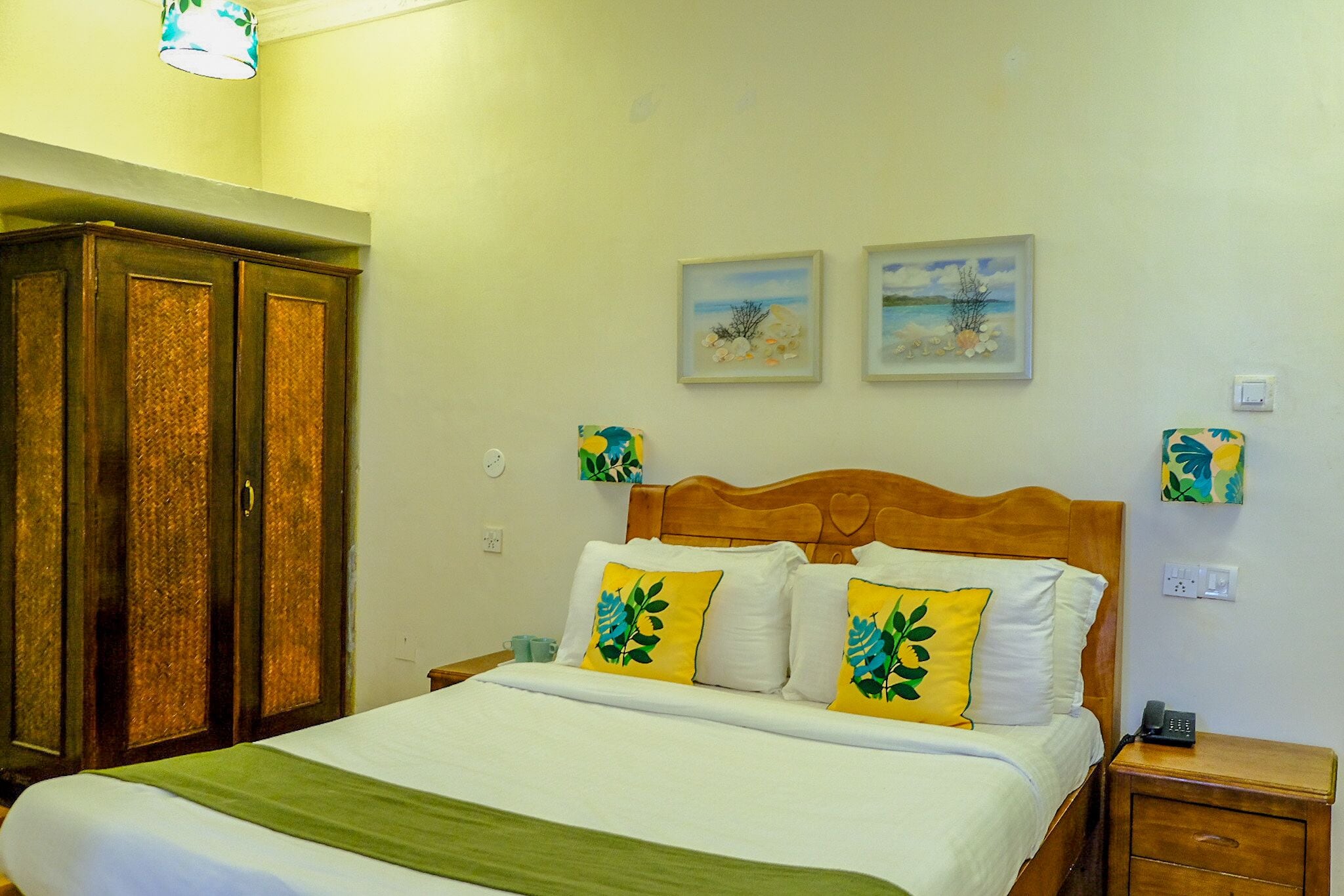 Uma cama bem arrumada com cabeceira de madeira, duas mesas de cabeceira e um criado-mudo.