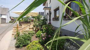 Um edifício residencial com jardim, área de estar externa e jardineiras.