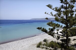 Na praia, espreguiçadeiras, guarda-sóis, toalhas de praia