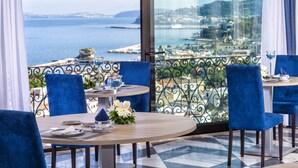 Espaço de refeições com vista para o mar e para a cidade.