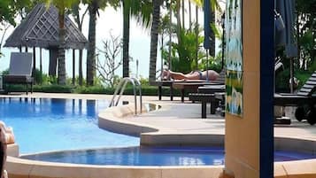 Uma área de piscina com espreguiçadeira e uma pequena cabana.