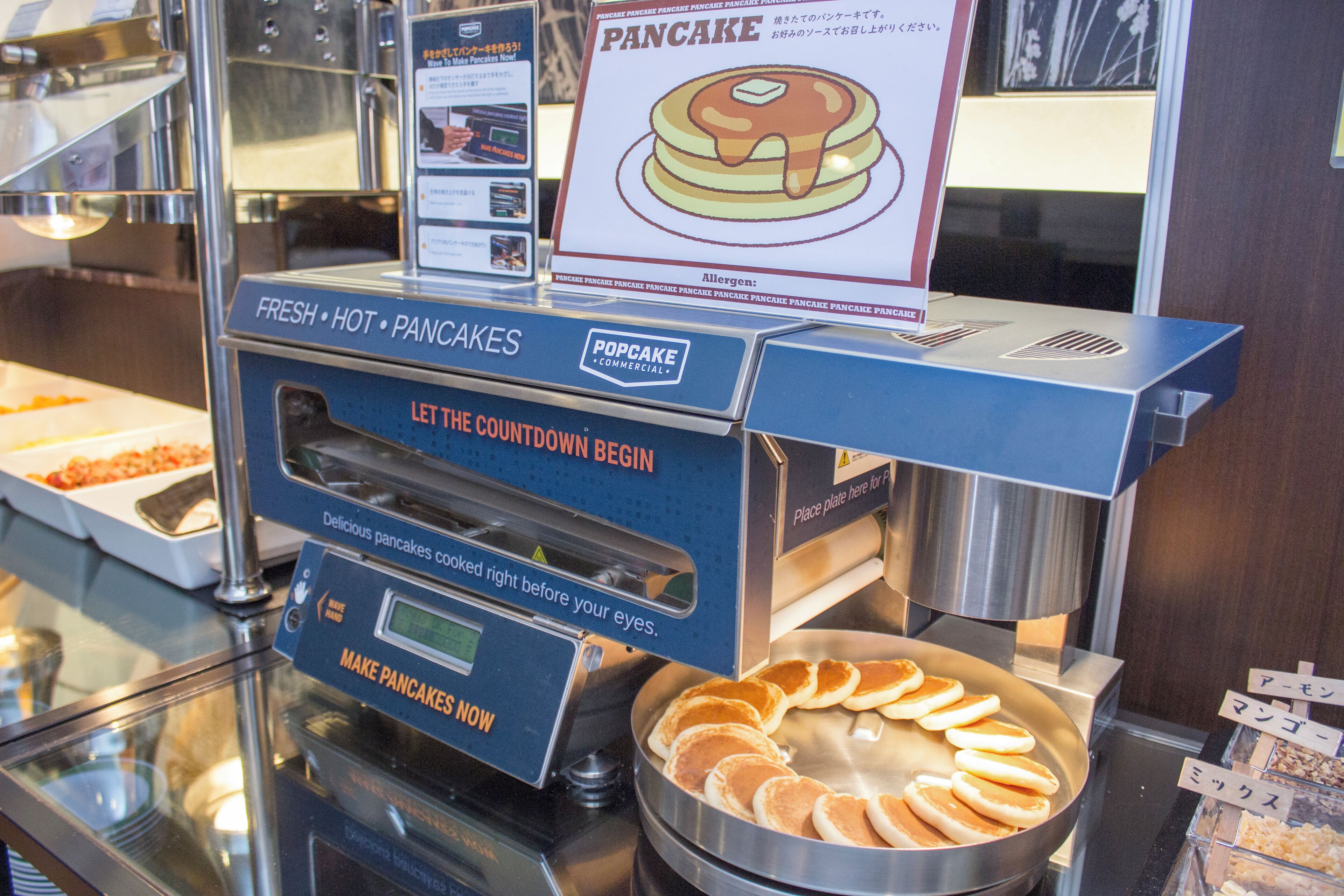 Uma mesa de panquecas com um letreiro anunciando panquecas frescas e quentes.