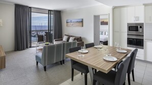 Quarto de hotel moderno com área de jantar, cama e cozinha.