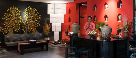 Sala de estar moderna com sofá, mesa de centro e objetos decorativos.