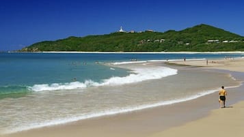 Na praia, areia branca, toalhas de praia