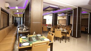 Um restaurante com mesas comunitárias grandes, cabines individuais e decoração interior moderna.