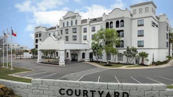 Um hotel Courtyard by Marriott com fachada de pedra, várias janelas e estacionamento.