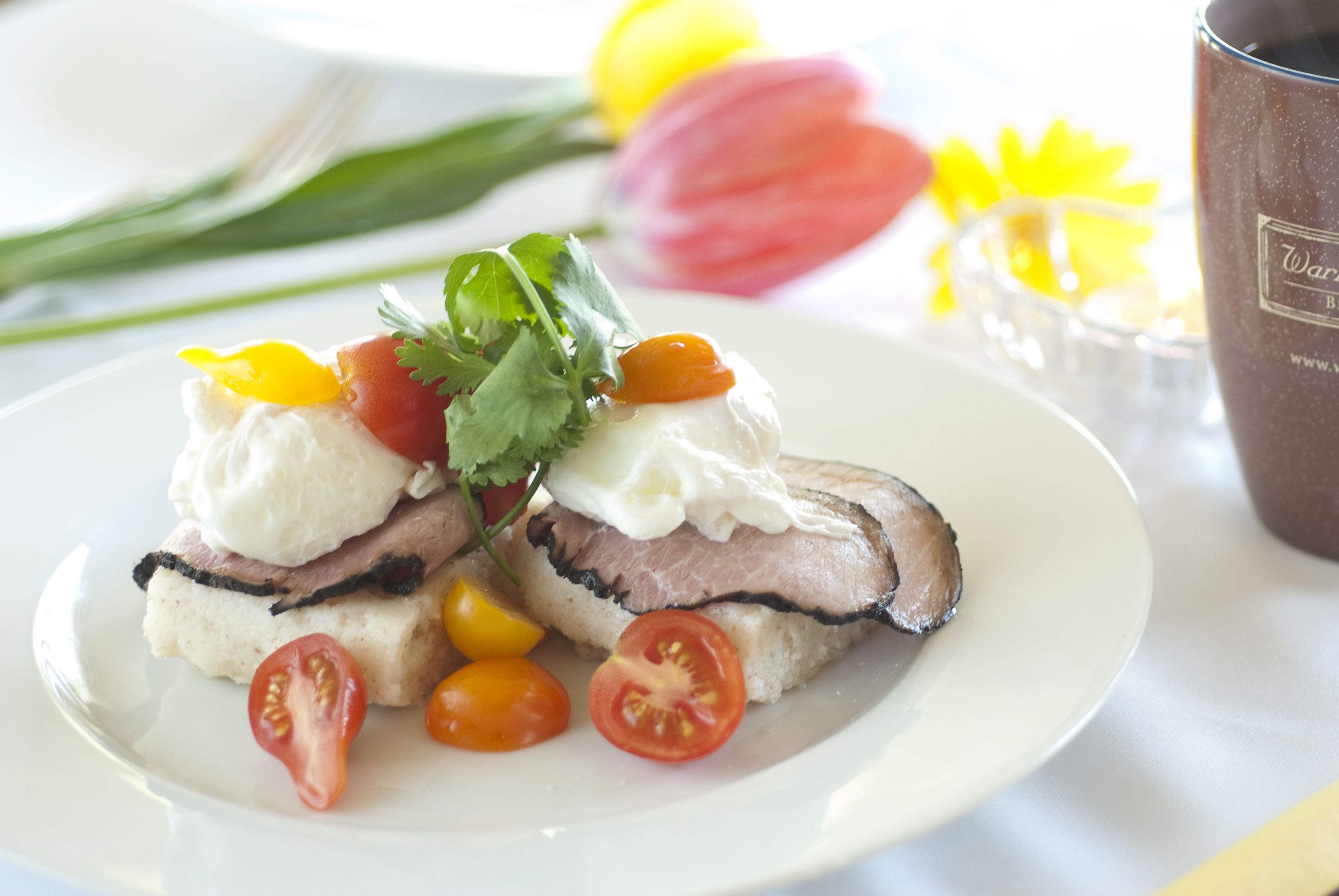 Um prato com carne fatiada, tomates e um enfeite.