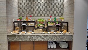 Uma mesa de buffet com diversos alimentos e bebidas.