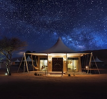 Alojamento em tenda com vista para o céu noturno, incluindo estrelas e a Via Láctea.