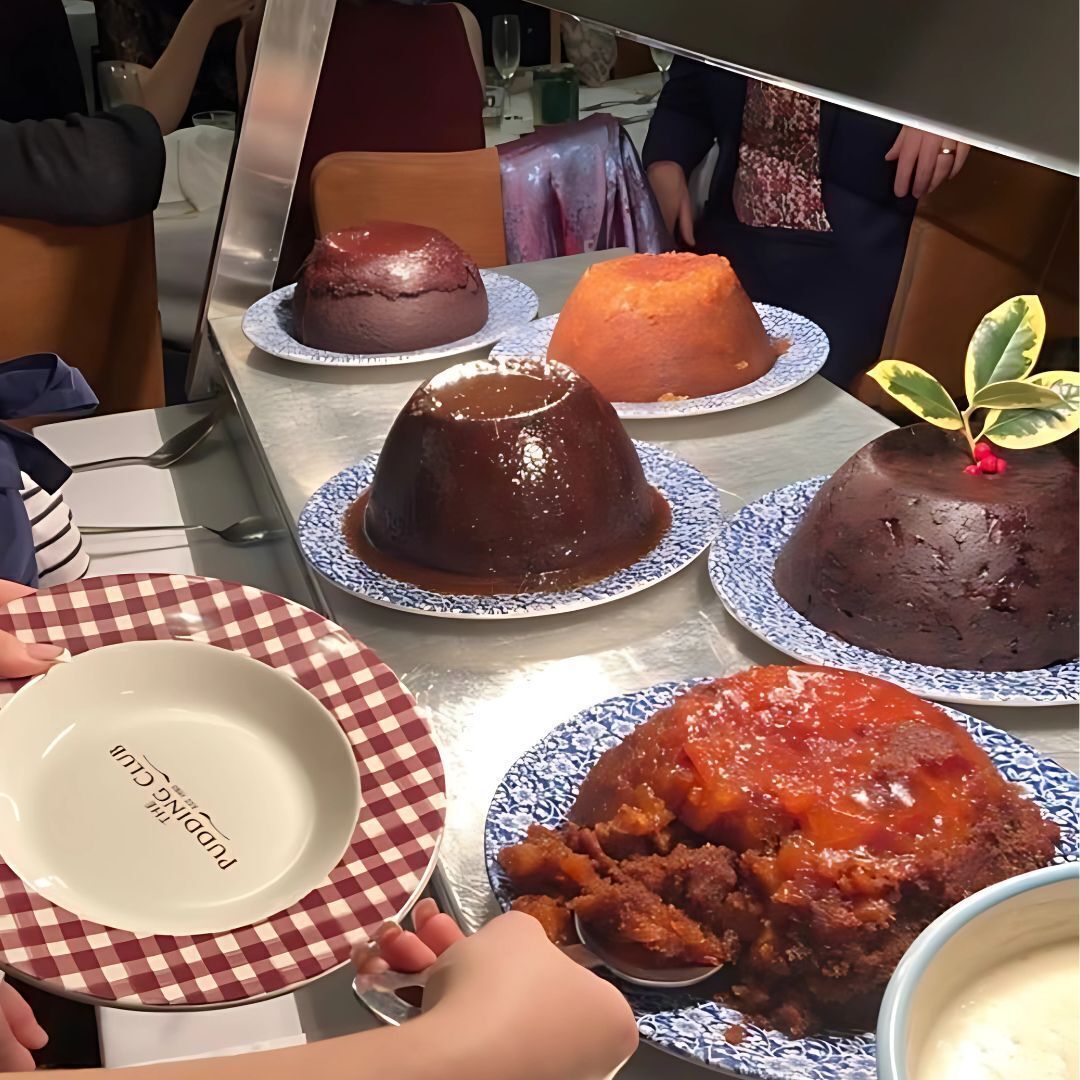 Uma mesa com diversos doces e um prato de comida, possivelmente em um restaurante ou evento.
