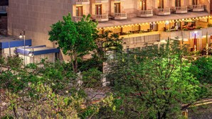 Um hotel com vários andares, varandas e uma área no terraço com painéis solares.