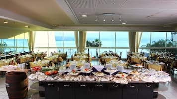 Uma mesa de buffet com várias mesas e uma ampla vista pela janela.